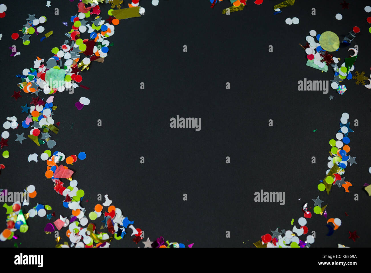 Overhead of confetti on black background Stock Photo - Alamy