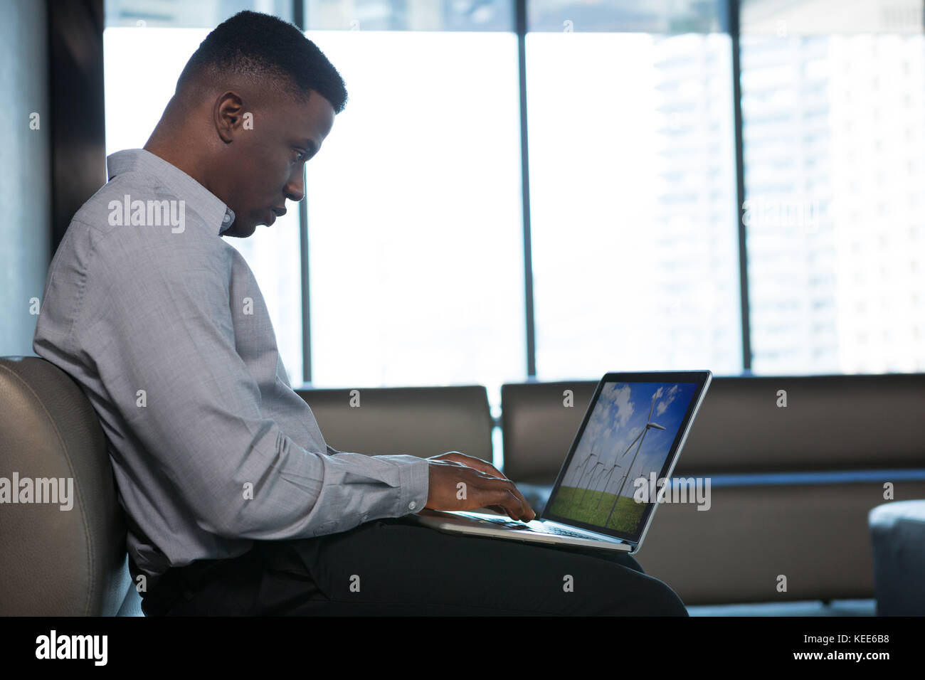 Male executive using laptop in futuristic office Stock Photo - Alamy