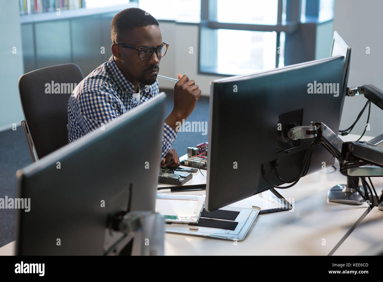 Computer engineer repairing motherboard at desk in office Stock Photo ...