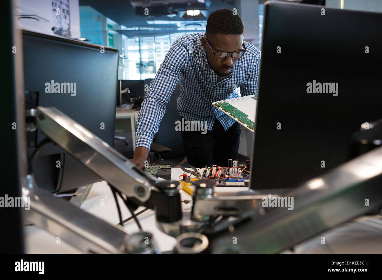Computer engineer repairing motherboard at desk in office Stock Photo ...