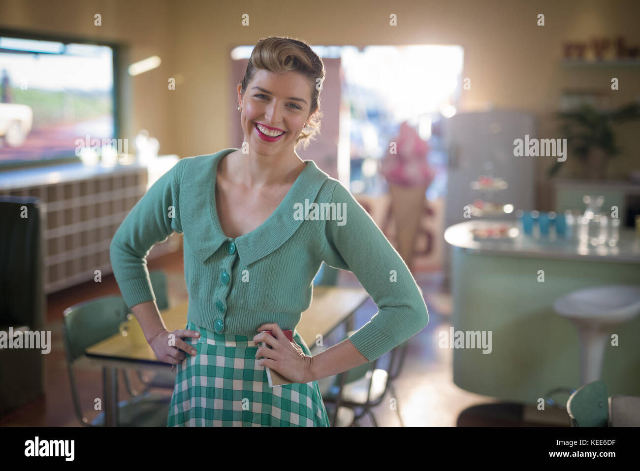 Waitress standing with hands on hips in restaurant Stock Photo - Alamy