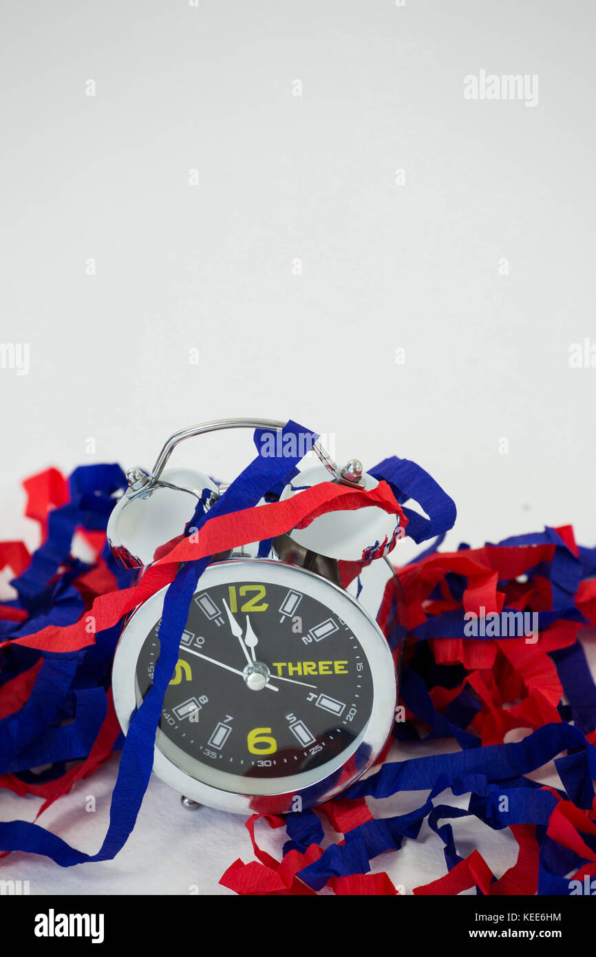 Close-up of alarm clock and streamers against white background Stock ...