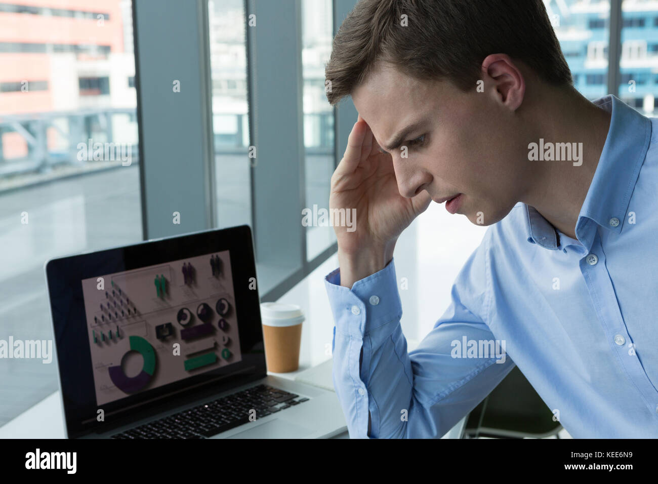 Depressed male executive sitting at desk in futuristic office Stock ...