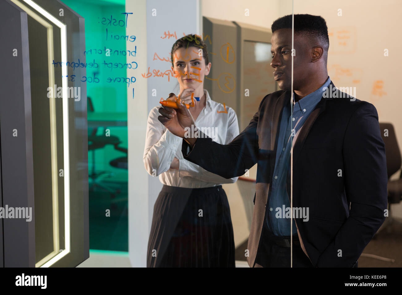 Male executive writing on glass in office Stock Photo - Alamy