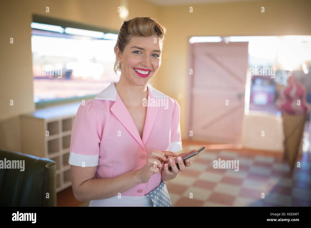 Young waitress using mobile phone in restaurant Stock Photo - Alamy
