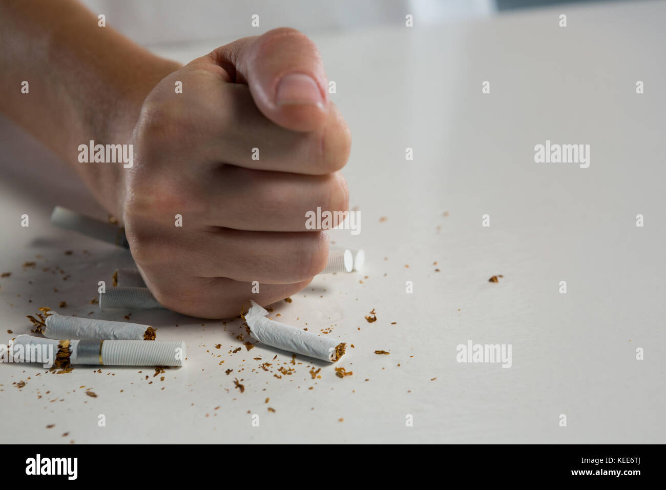 Woman breaking cigarette with fist on white background Stock Photo - Alamy