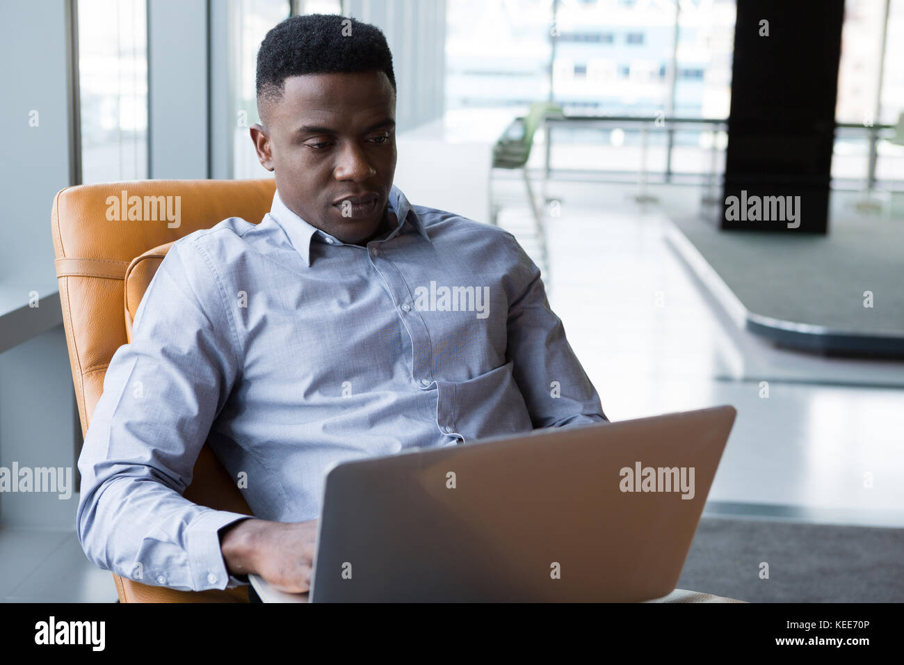 Male executive using laptop in futuristic office Stock Photo - Alamy