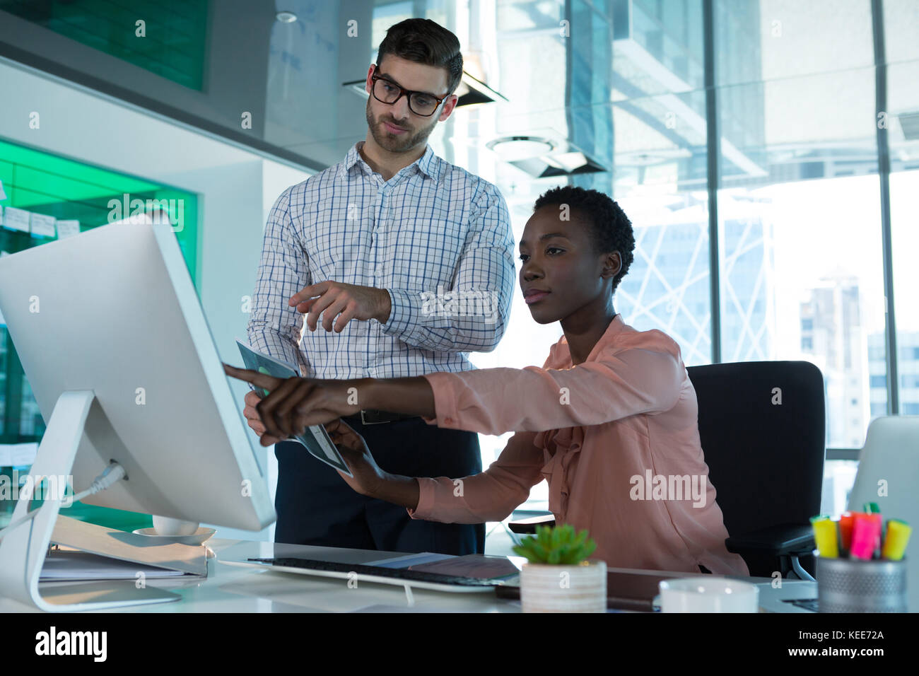 Business executives discussing over desktop hi-res stock photography ...