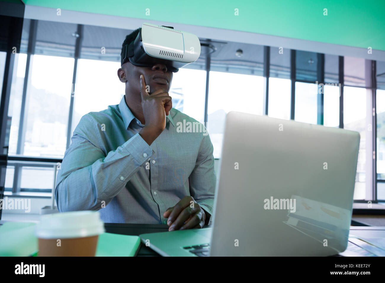 Male executive using virtual reality headset in futuristic office Stock ...