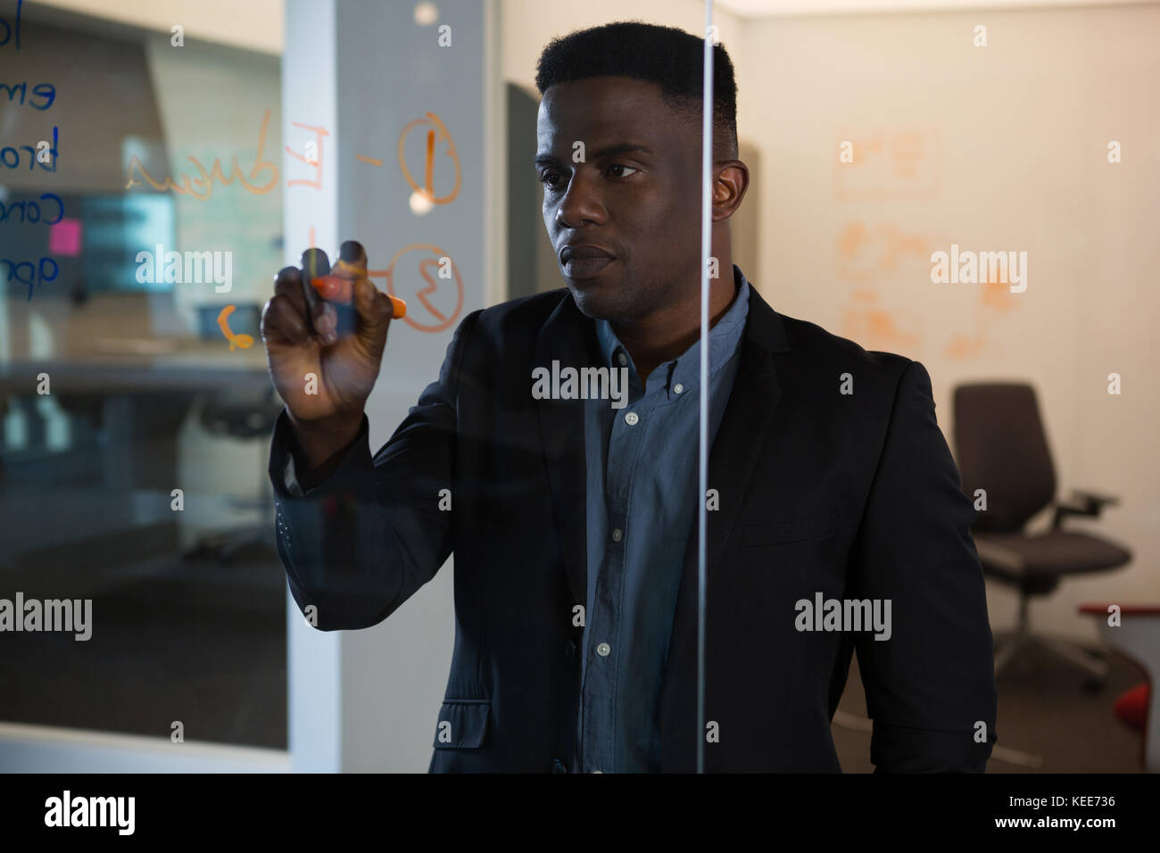 Male executive writing on glass in office Stock Photo - Alamy