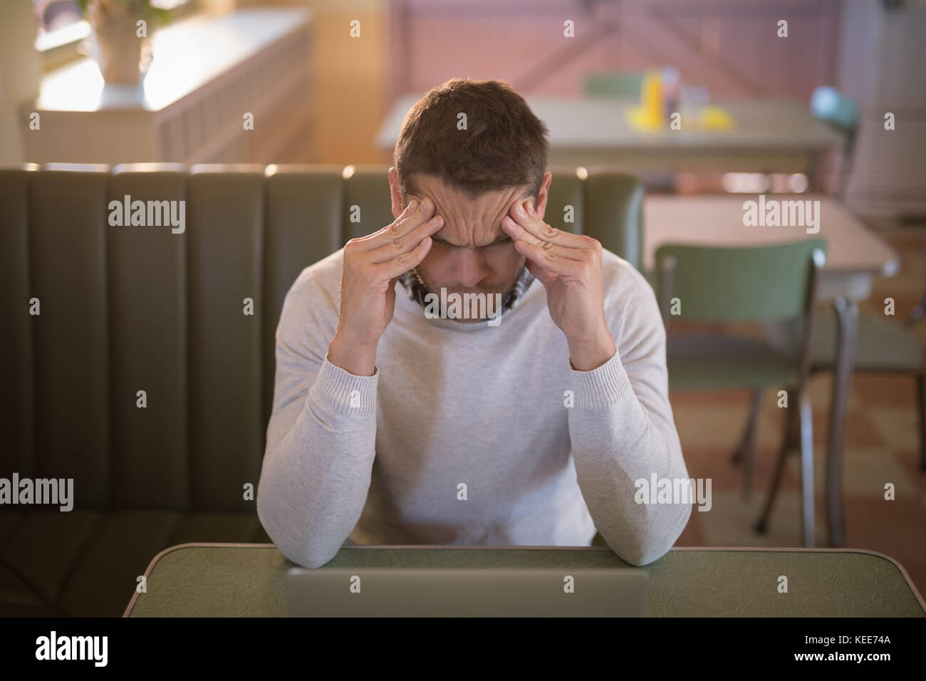 Young depressed man sitting in restaurant Stock Photo - Alamy