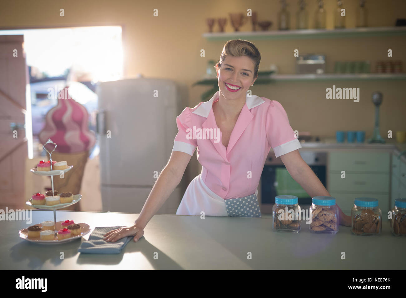 Happy waitress standing at counter in restaurant Stock Photo - Alamy