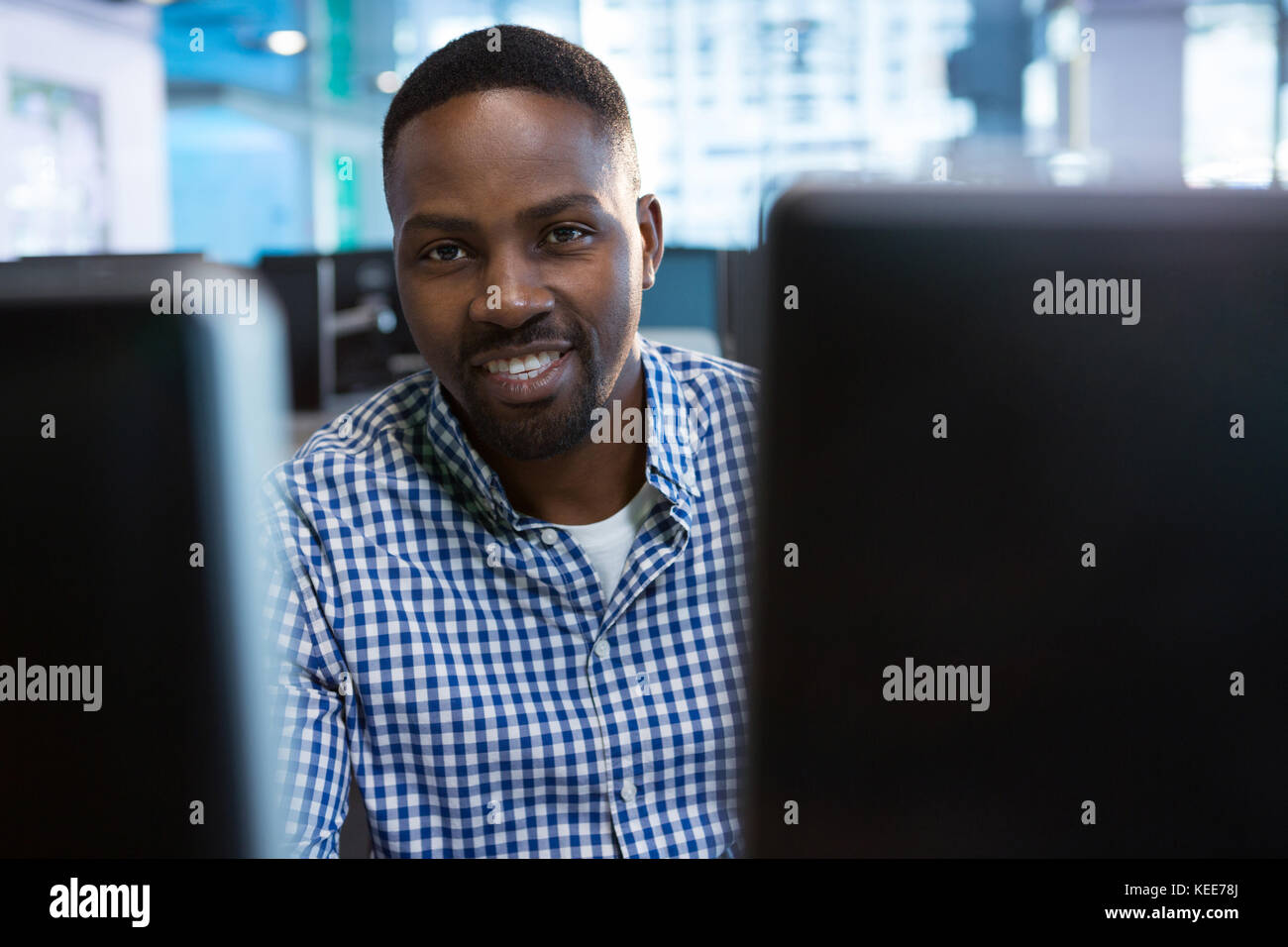 Portrait of computer engineer sitting at desk in office Stock Photo - Alamy
