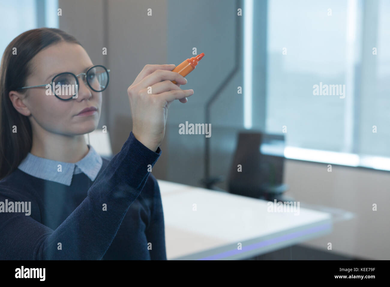 Female executive writing on glass in office Stock Photo - Alamy