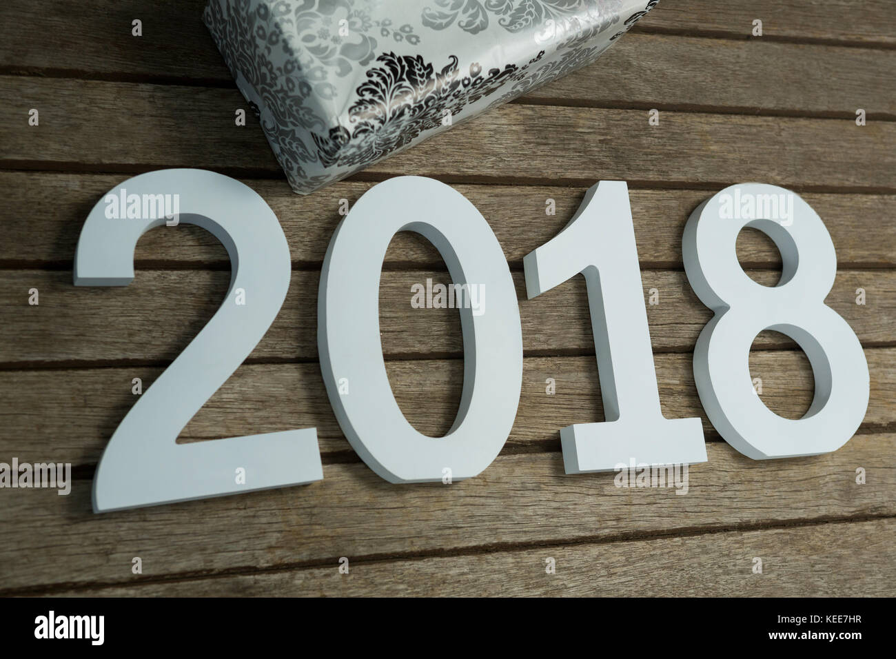 Close-up of New year number 2018 with gift box kept on the wooden ...