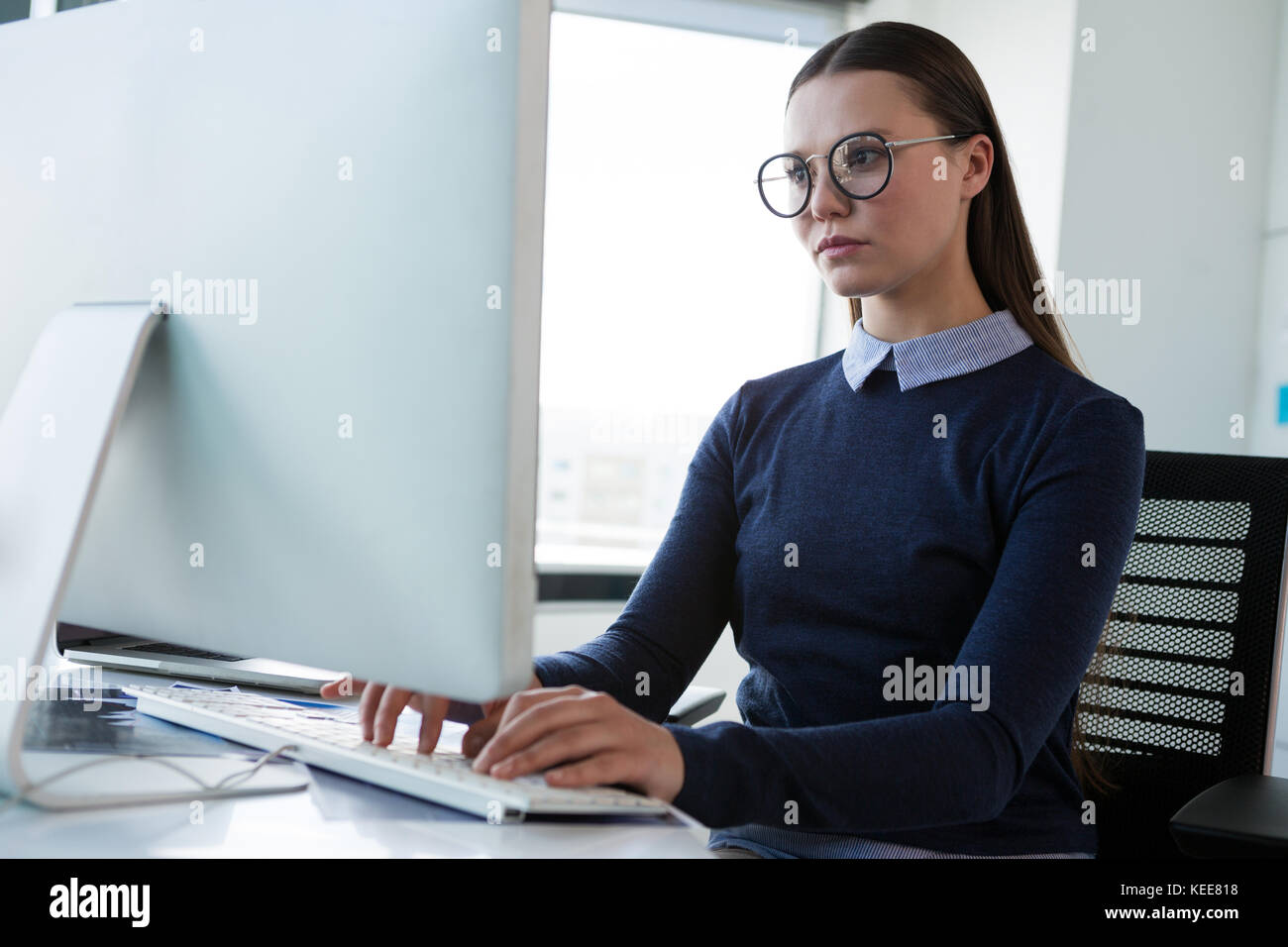 Female executive working on personal computer at desk in office Stock ...