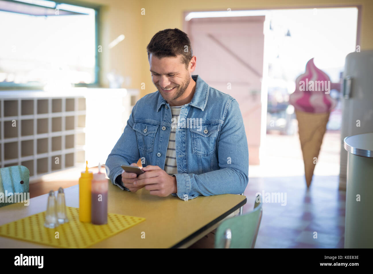 Young man using mobile phone in restaurant Stock Photo - Alamy