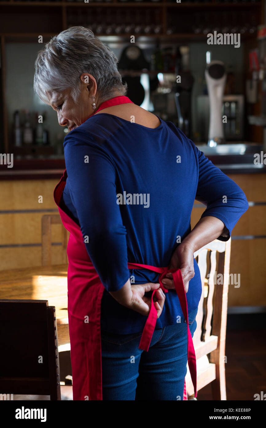 Waitress wearing her apron in the bar Stock Photo - Alamy