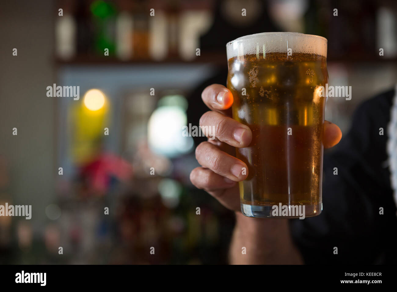 Mid-section of bar tender offering beer Stock Photo - Alamy
