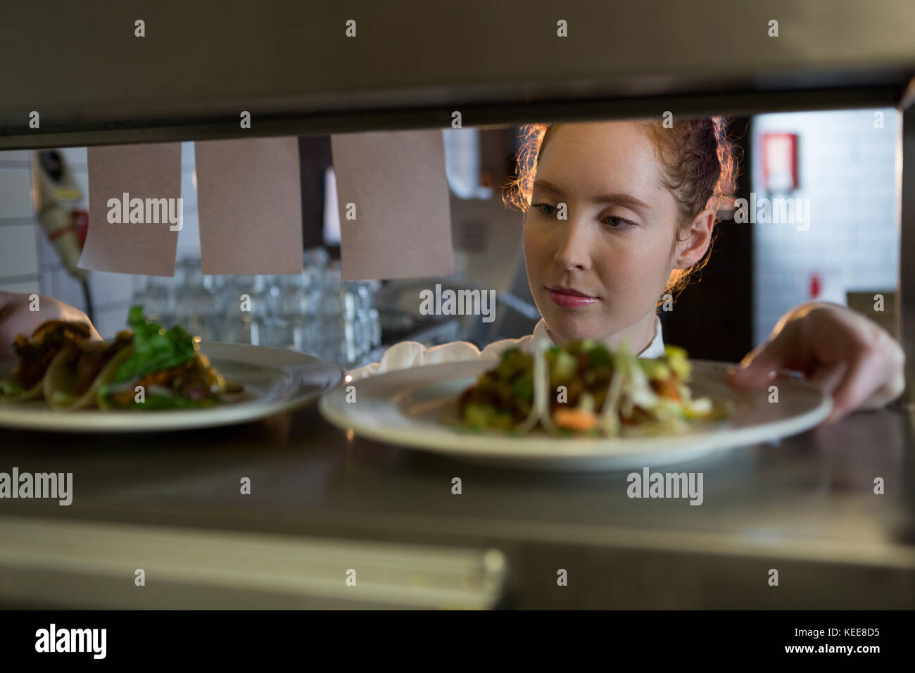 Female chef reading order in the kitchen Stock Photo - Alamy