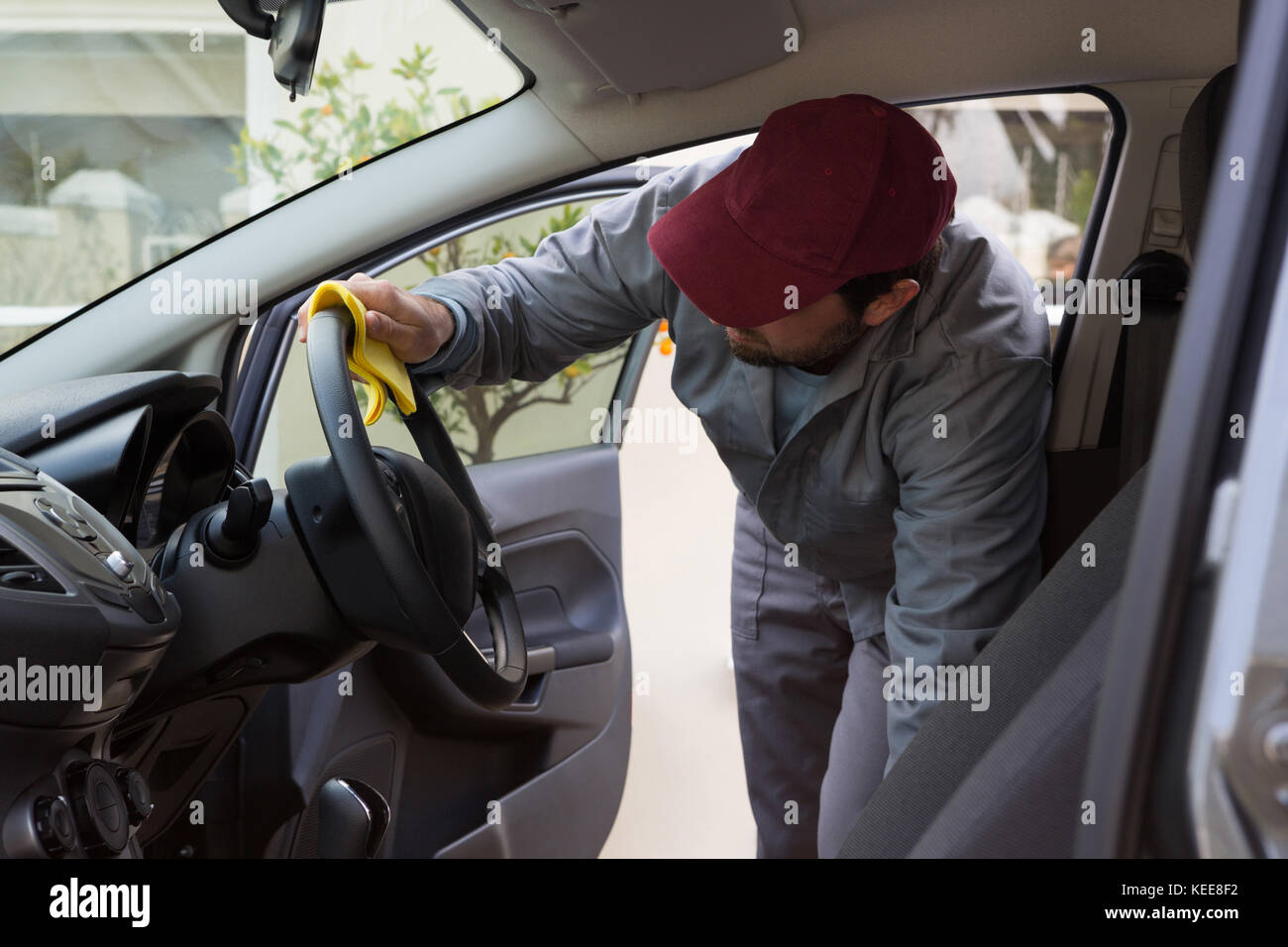 Male auto service staff cleaning car interior Stock Photo - Alamy