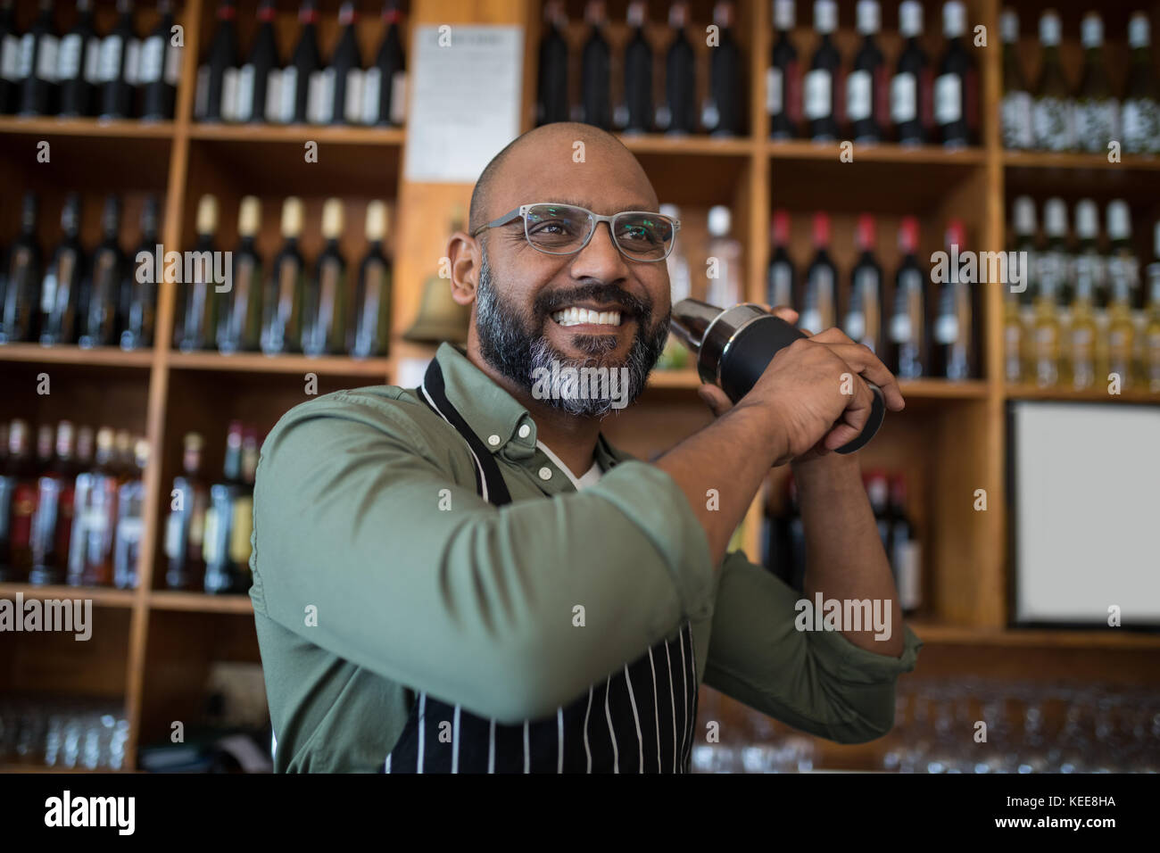 Smiling waiter shaking cocktail in bar Stock Photo - Alamy