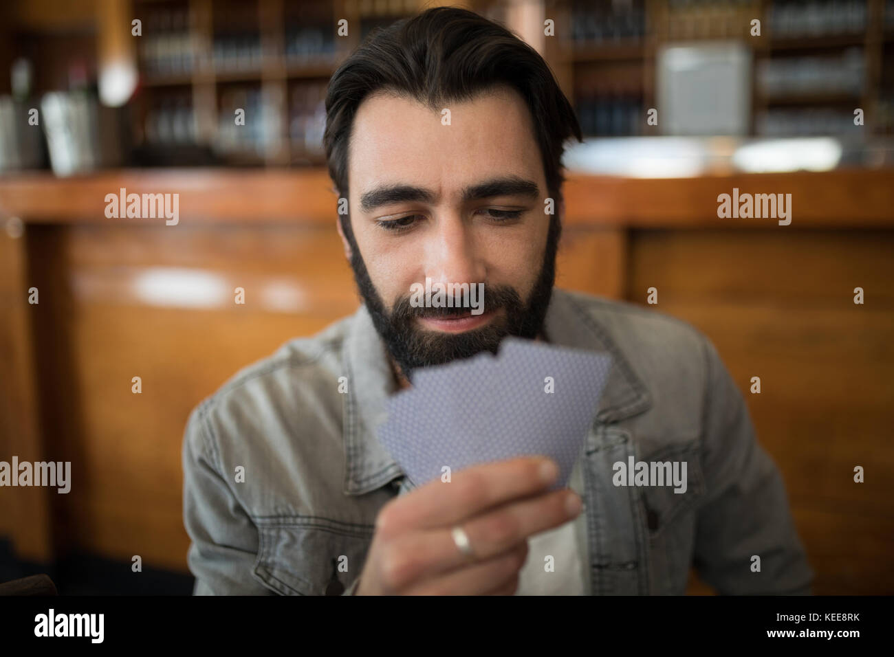 Confident man playing cards in bar Stock Photo - Alamy