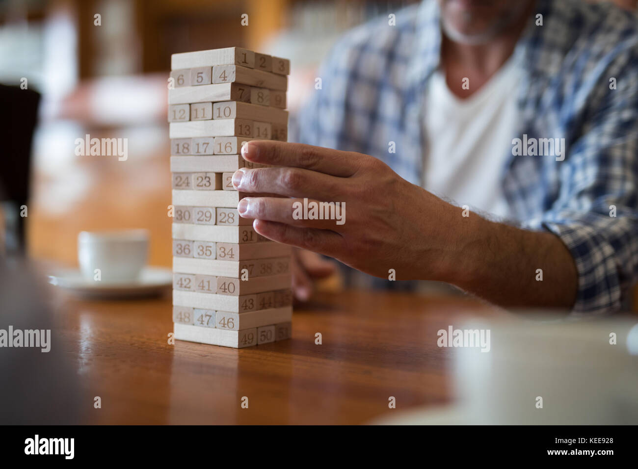 Mid section of man playing jenga game on table in bar Stock Photo - Alamy