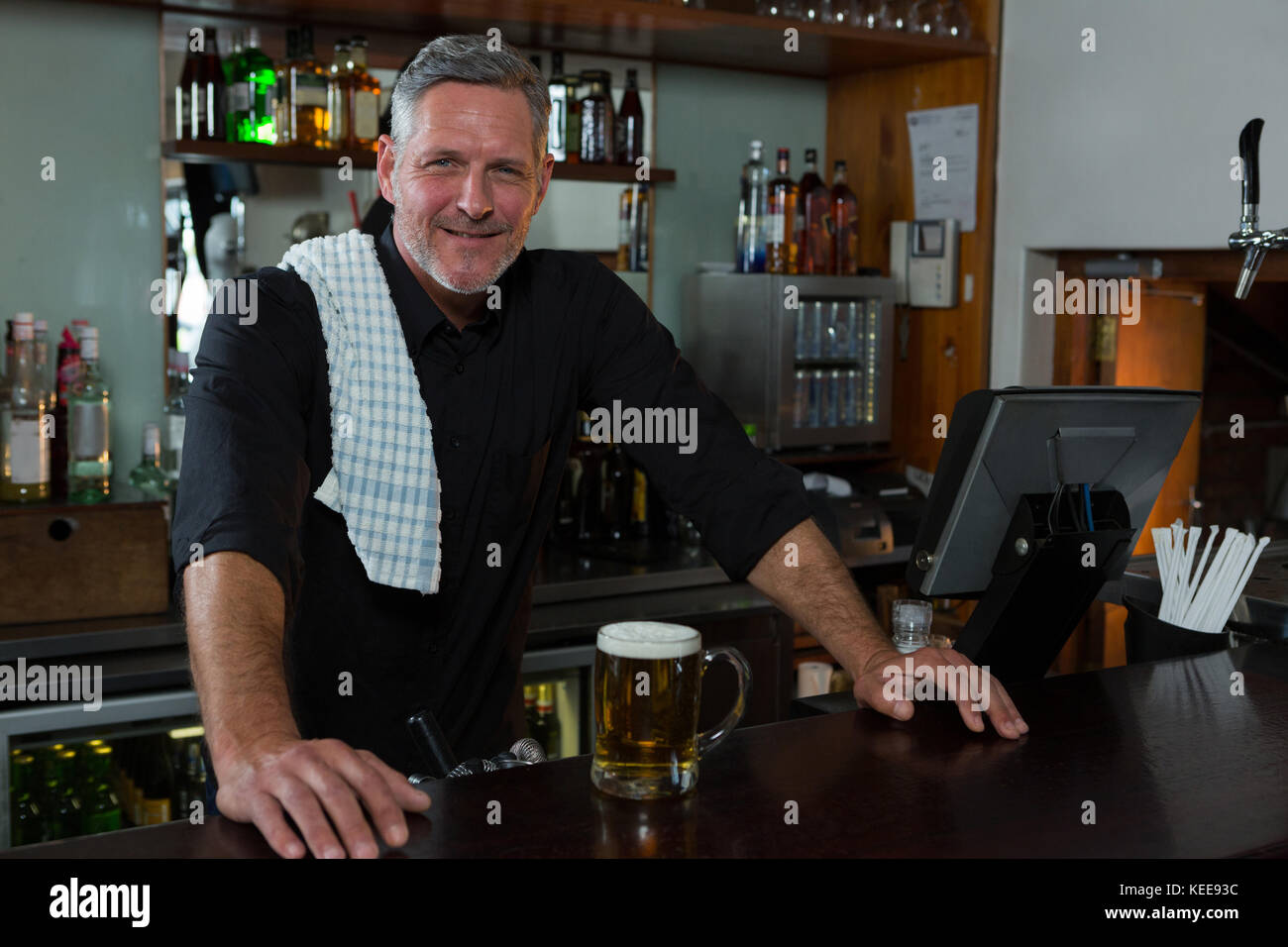 Portrait of happy bar tender leaning at bar counter Stock Photo - Alamy