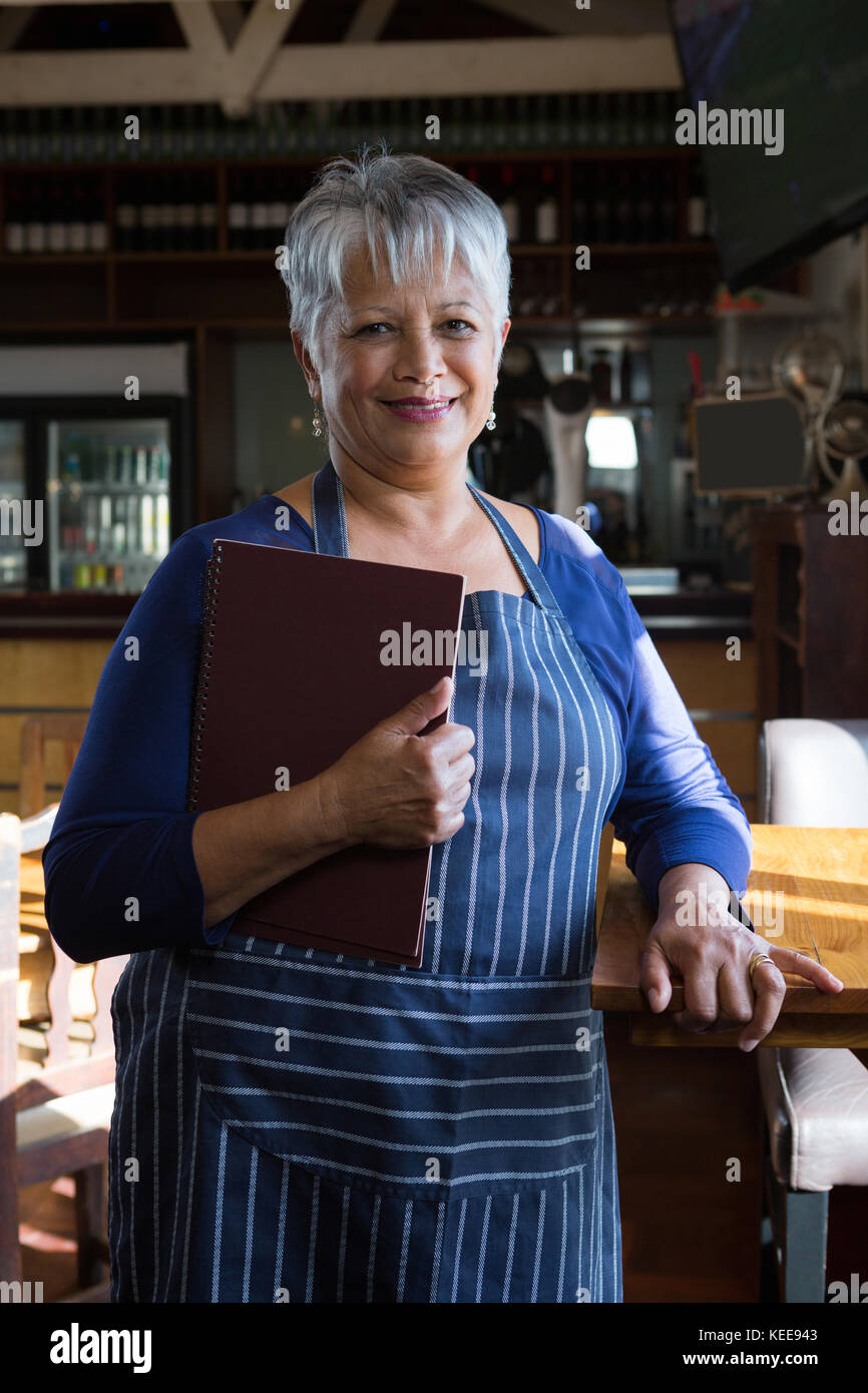 Waitress holding menu card at the bar Stock Photo - Alamy