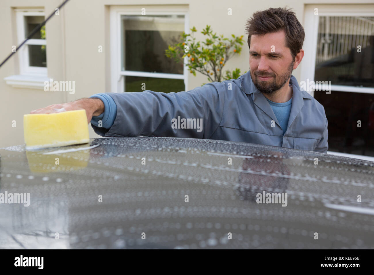 Male auto service staff washing a car roof with sponge Stock Photo - Alamy
