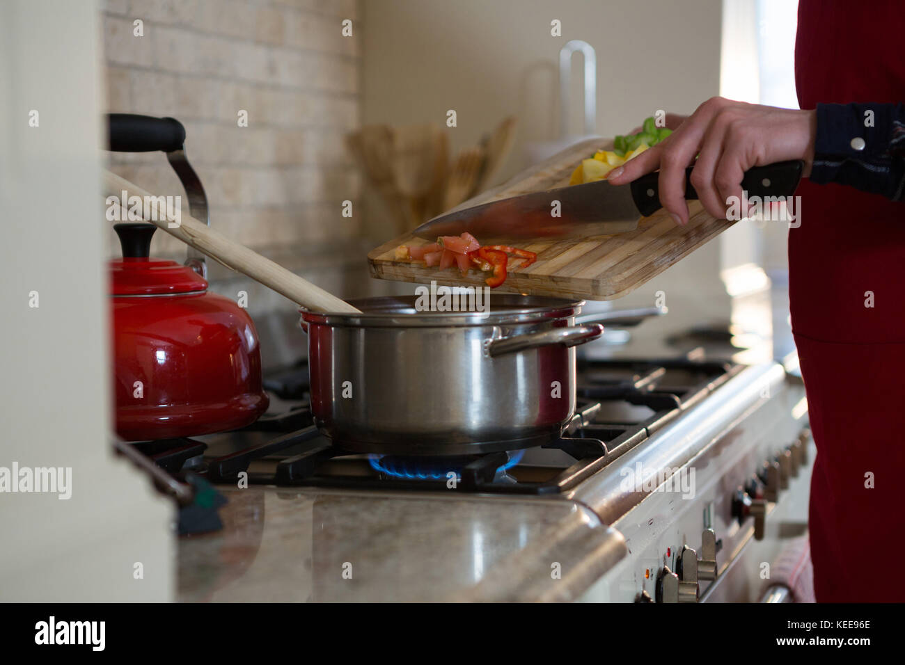 Mid section of woman cooking food in kitchen at home Stock Photo - Alamy
