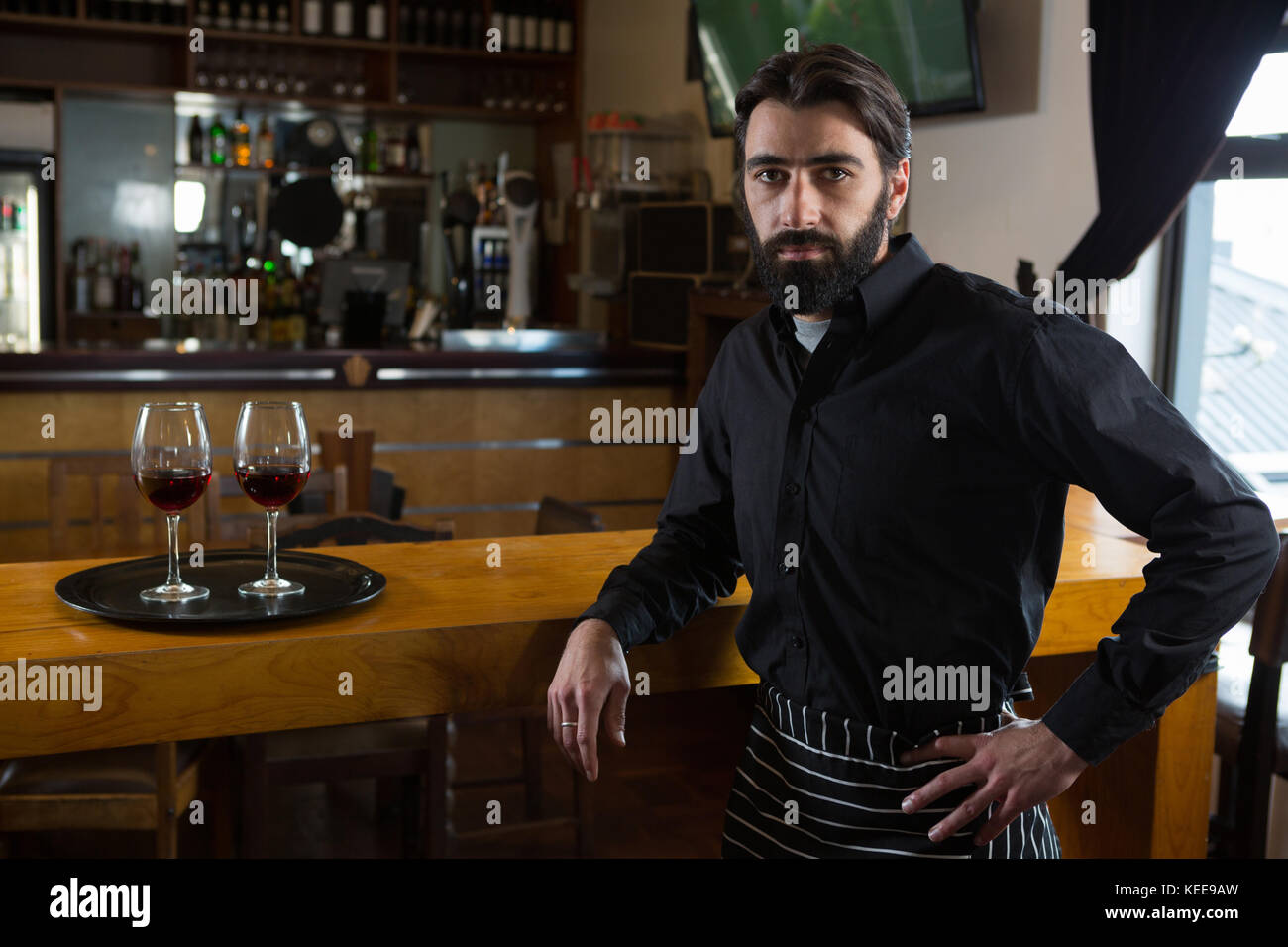 Portrait of happy bar tender leaning at bar counter Stock Photo - Alamy