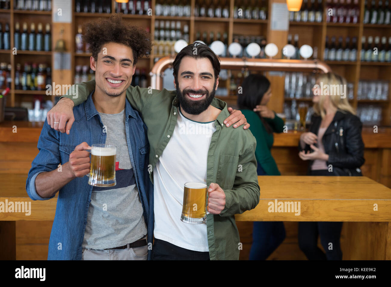 Portrait of smiling two friends having glass of beer in bar Stock Photo ...