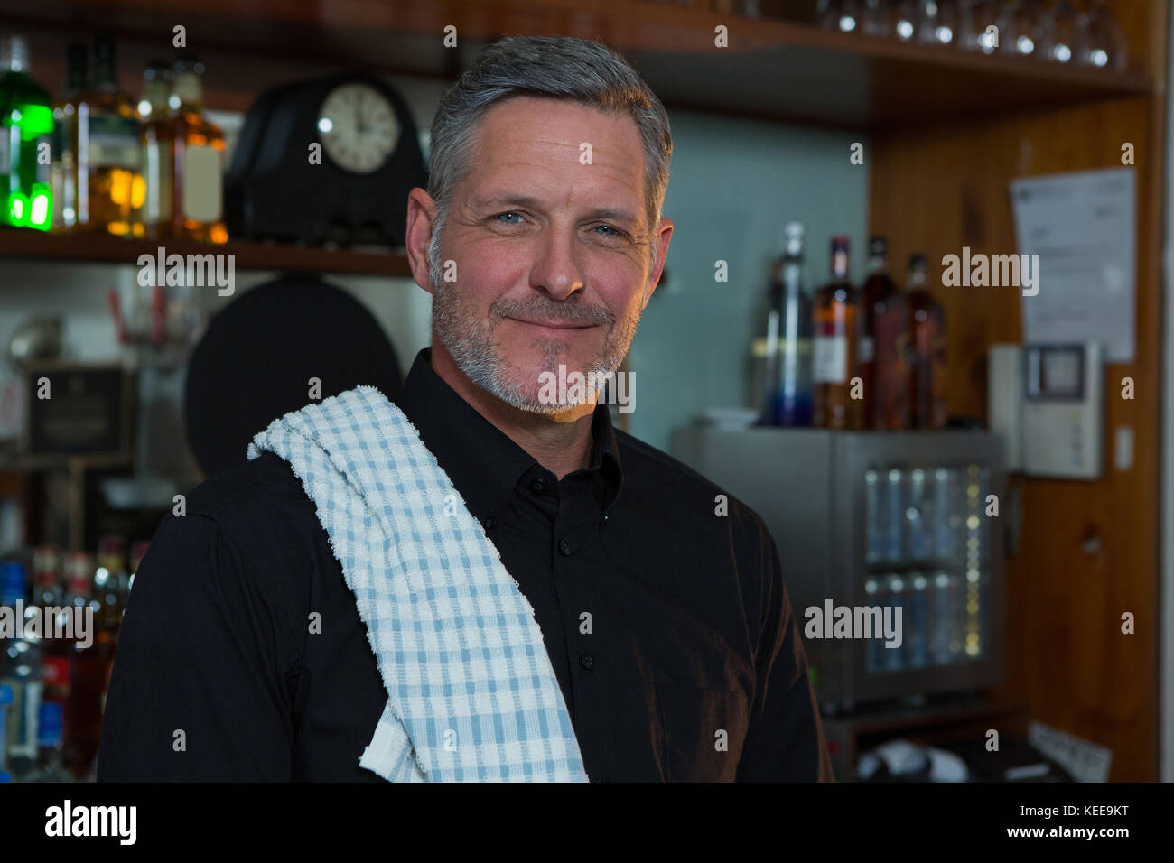 Portrait of bar tender standing at bar counter Stock Photo - Alamy