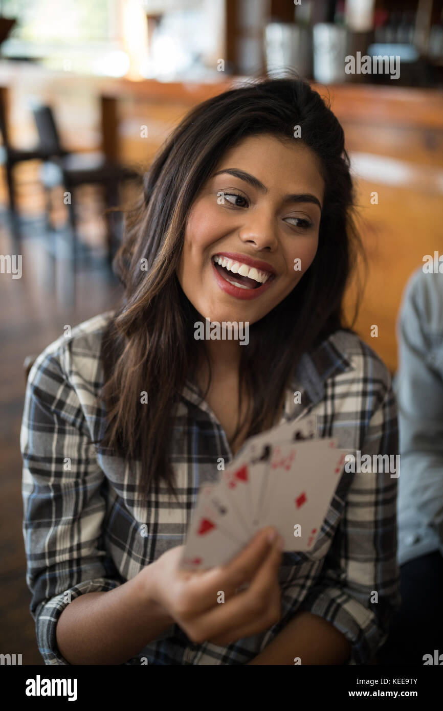 Smiling beautiful woman playing cards in bar Stock Photo - Alamy