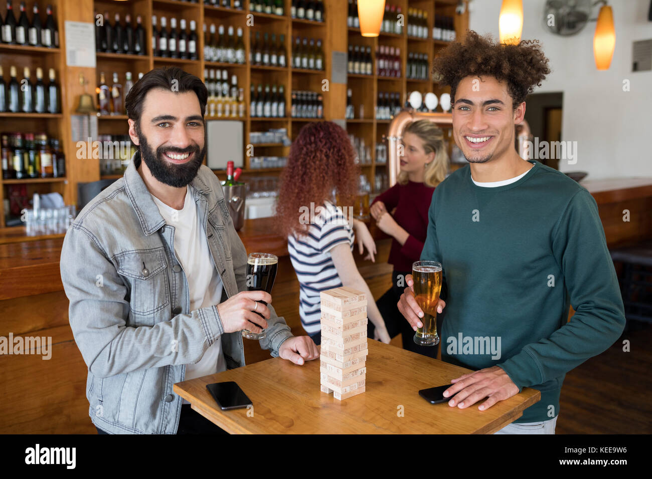 Portrait of smiling two friends having glass of beer in bar Stock Photo ...