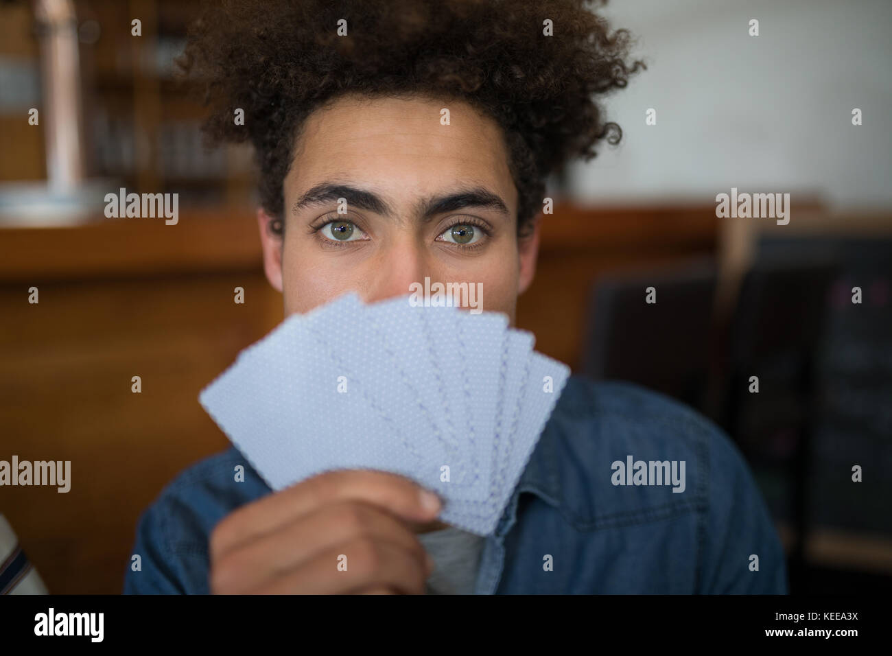 Portrait of man showing cards in bar Stock Photo - Alamy