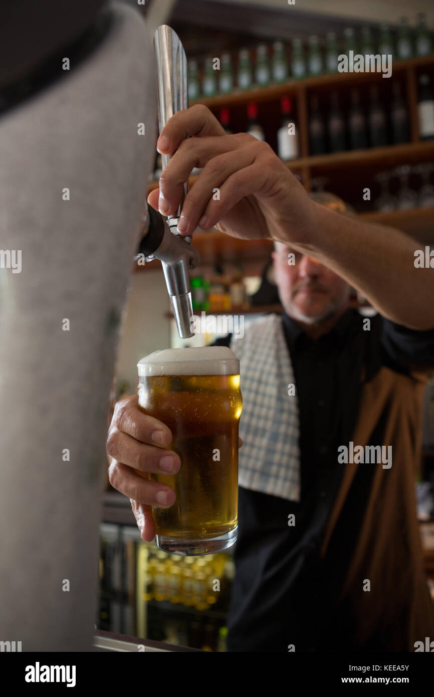 Brewer filling beer in beer glass from beer pump in bar Stock Photo - Alamy