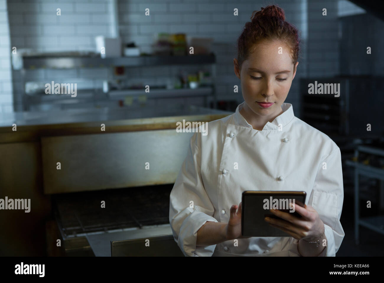 Female chef using digital tablet in the kitchen Stock Photo - Alamy