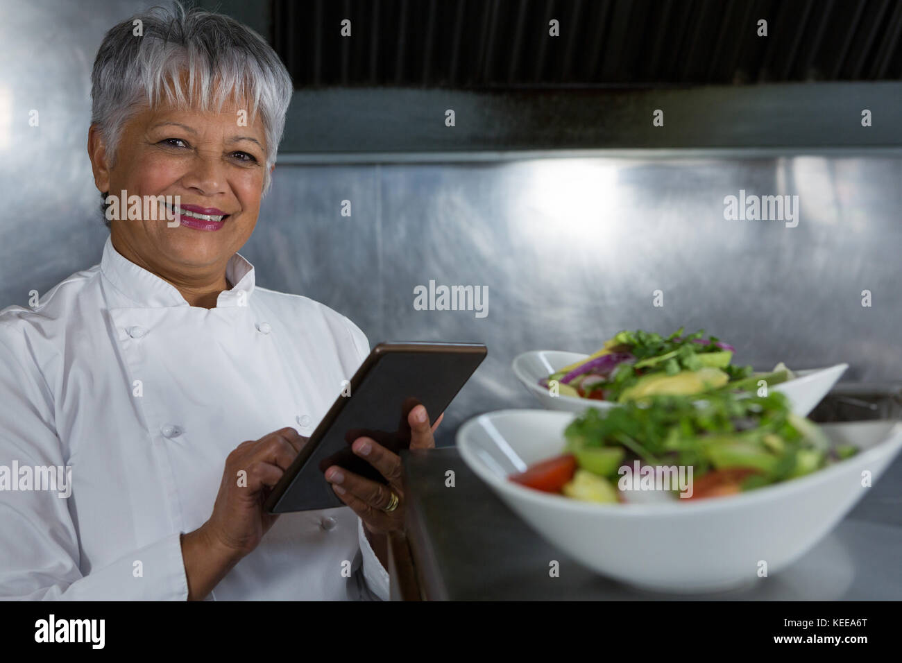 Female chef using digital tablet in the kitchen Stock Photo - Alamy