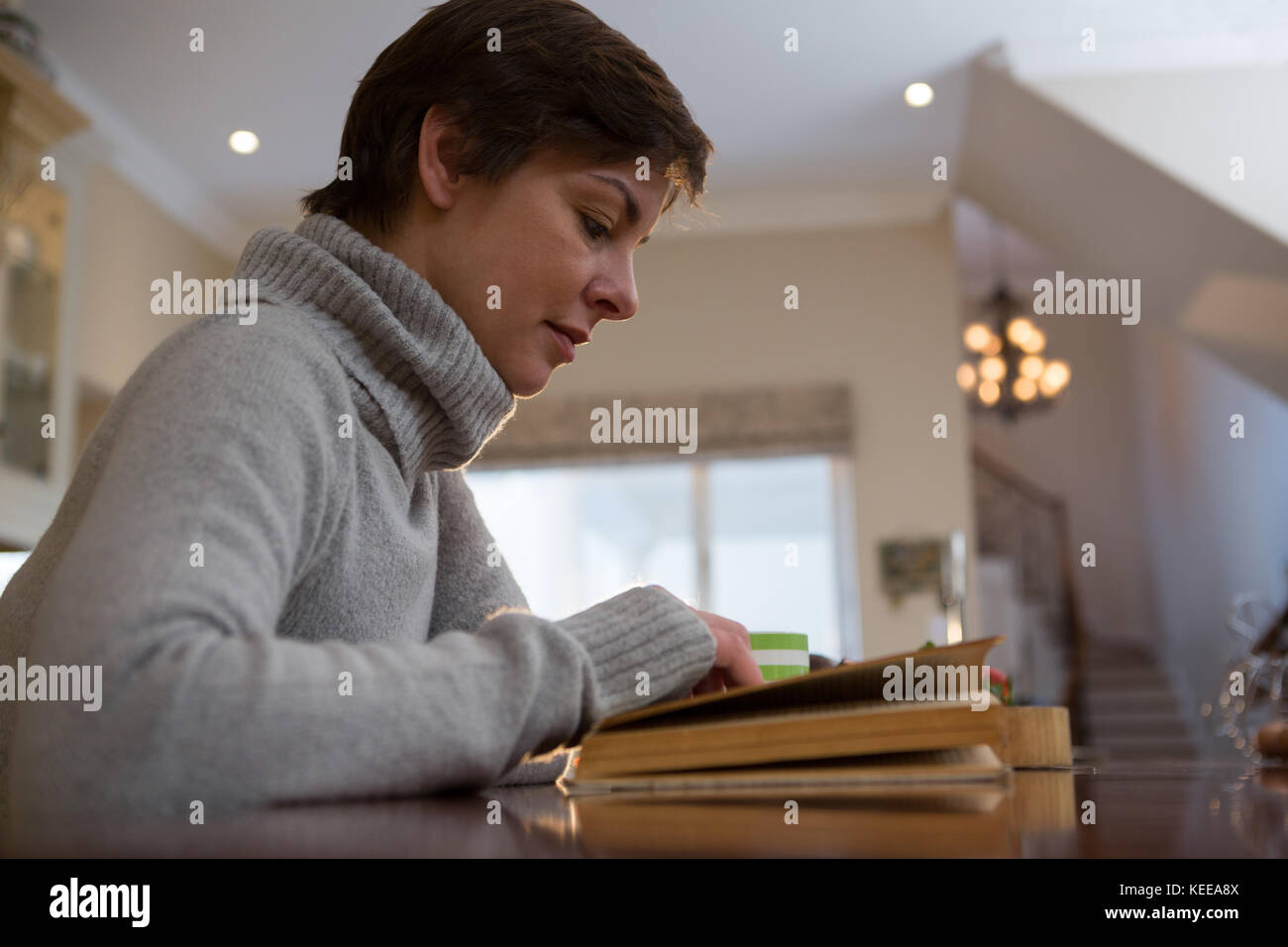 Beautiful woman reading book at home Stock Photo - Alamy