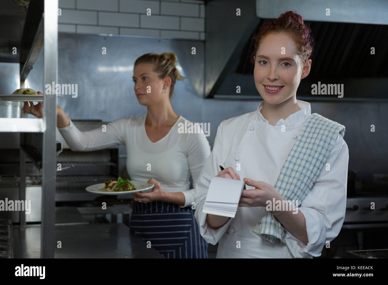Female writing in the notepad in the kitchen Stock Photo - Alamy