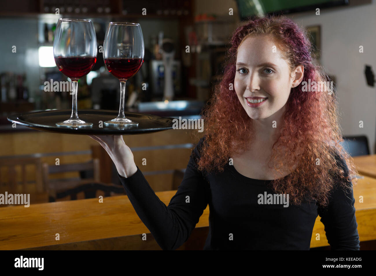 Portrait of beautiful waitress holding wine glasses Stock Photo - Alamy