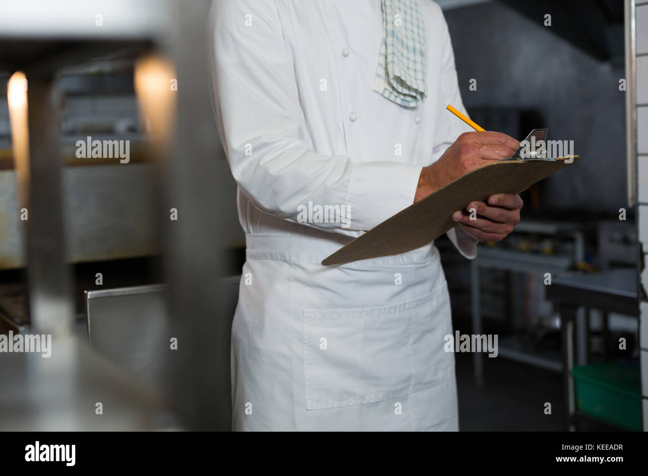 Mid-section of male chef writing order on a clipboard Stock Photo - Alamy