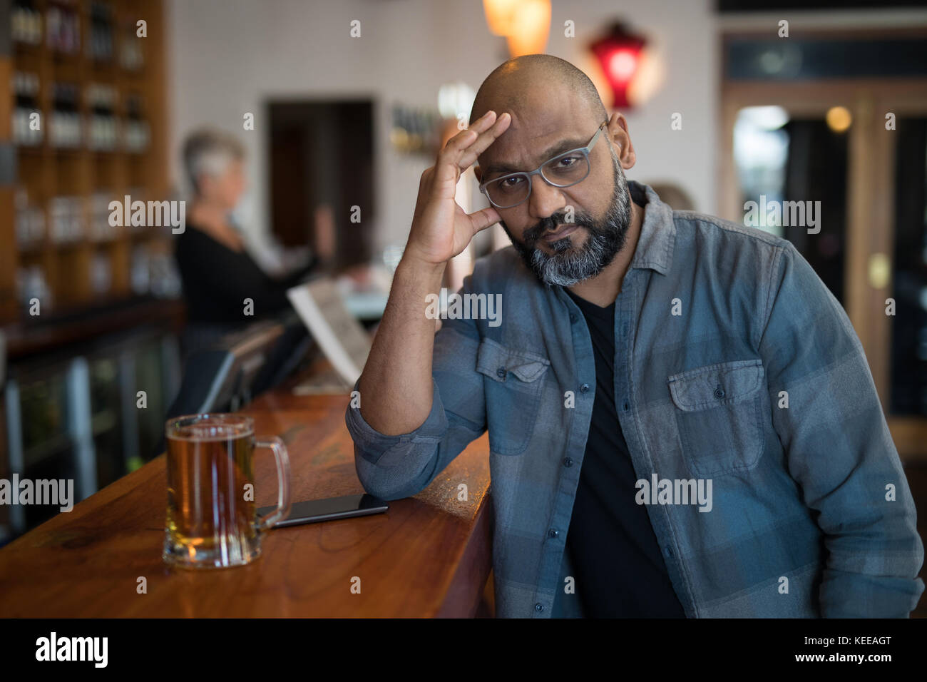 Depressed man sitting at counter in bar Stock Photo - Alamy