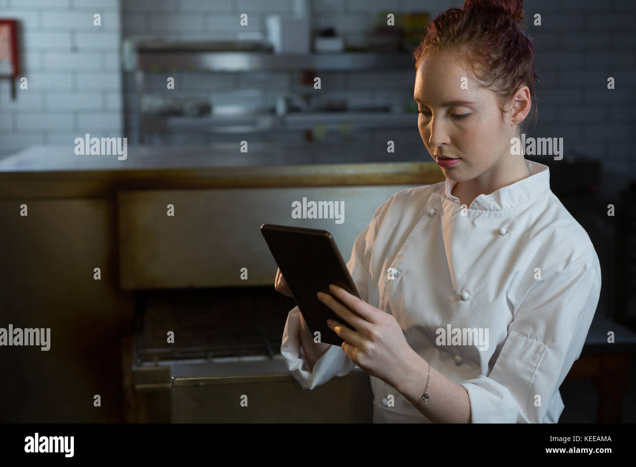 Female chef using digital tablet in the kitchen Stock Photo - Alamy