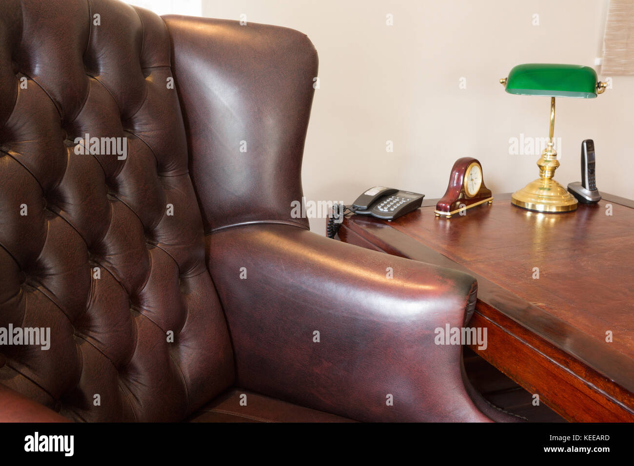 Arm chair with telephone, alarm clock and lamp on table at home Stock ...