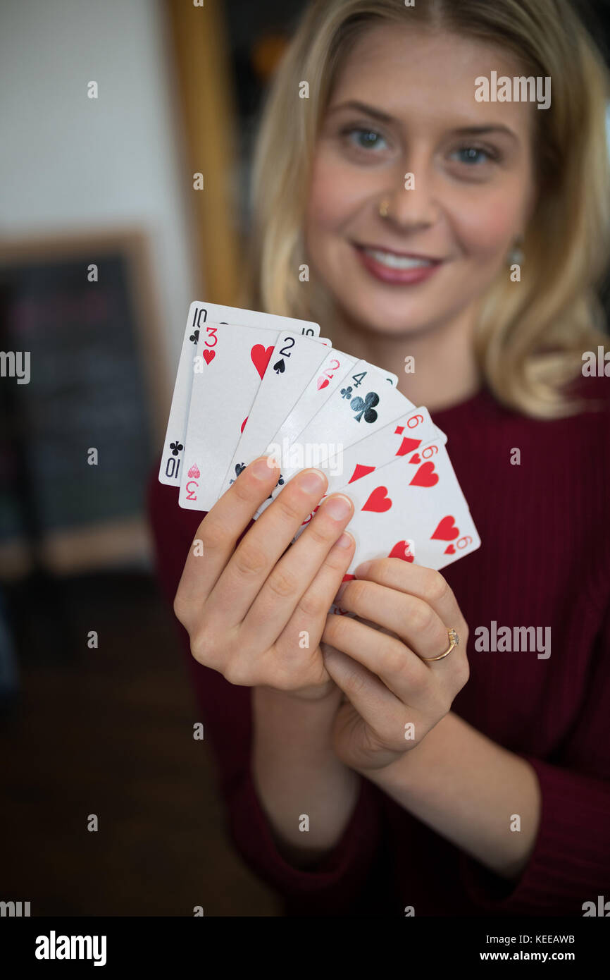 Portrait of smiling beautiful woman showing cards in bar Stock Photo ...