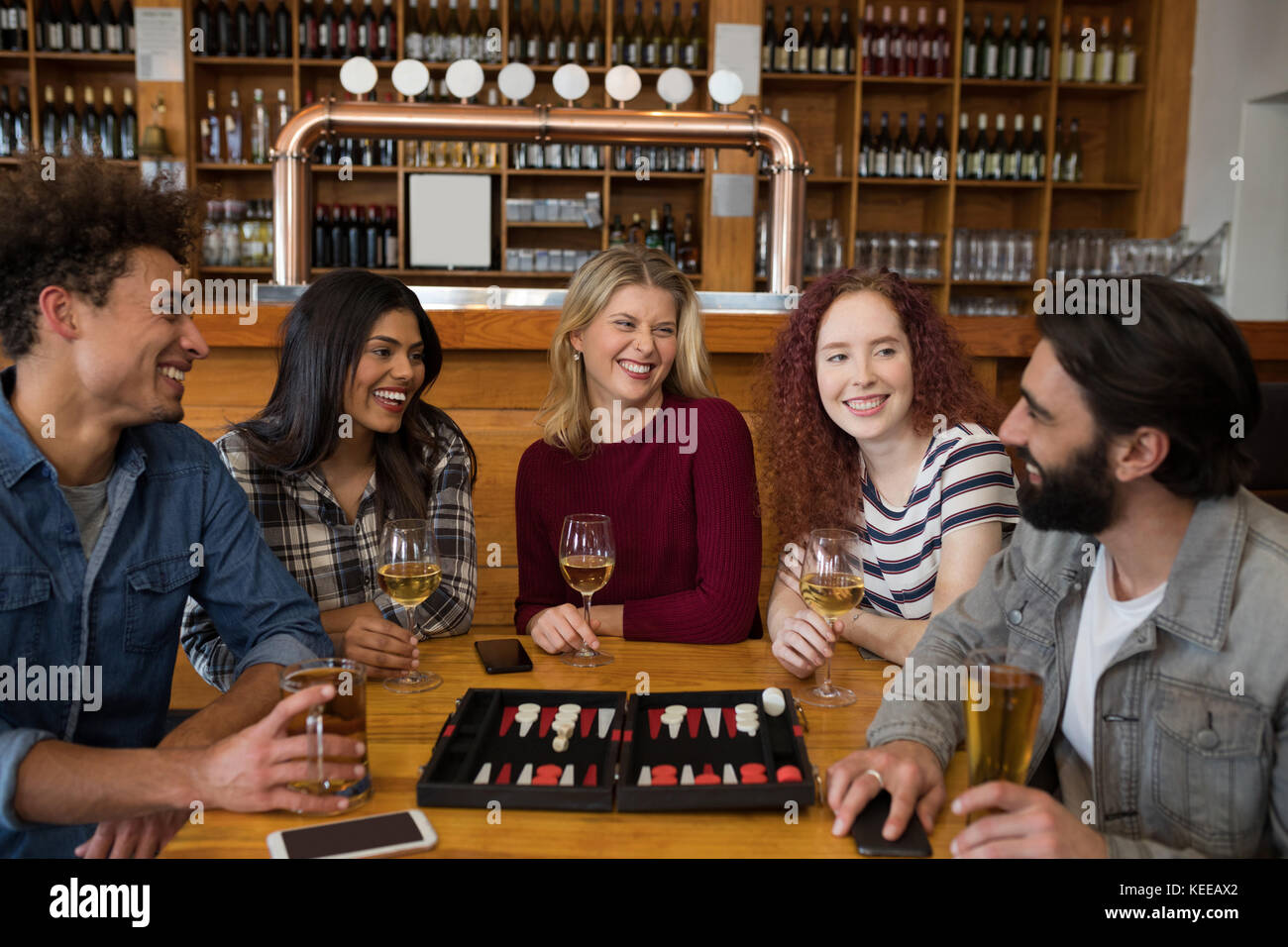 Happy friends interacting while having glass of beer in bar Stock Photo ...